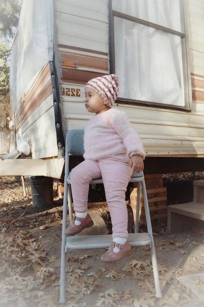 Premium Photo Cute Girl Looking Away While Sitting On Chair