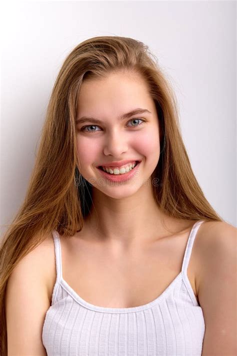Portrait Of Cheerful Caucasian Female With Long Natural Hair Looking At