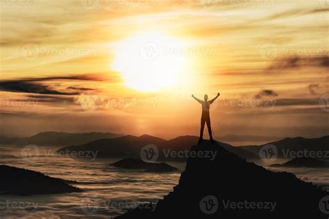 Silhouette Man Standing And Raise Two Hand On Peak Stone Rock In Mountain And Watching To