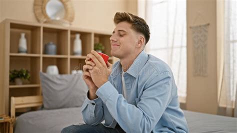 Attractive Young Caucasian Man Happily Kicking Back Drinking Espresso