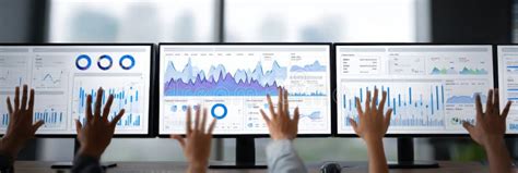 Hands Interacting With Multiple Monitors Displaying Data Analytics In A