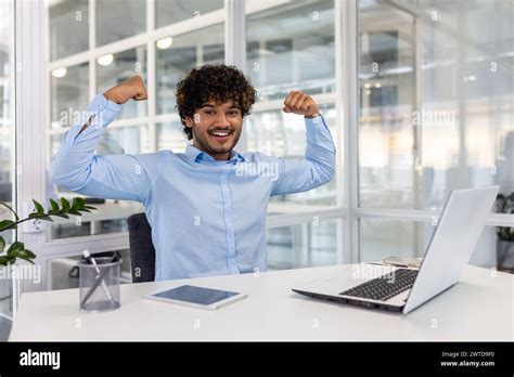 An Exuberant Professional Triumphantly Raises Their Fists In A Modern