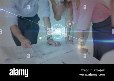 A Group Of Architects Are Looking Over Blueprints While One Smiles At