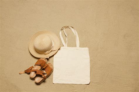 모형 쇼핑객 핸드백 해변 모래 배경 탑 뷰 복사 공간 쇼핑 에코 재사용 가능한 가방 플립 플롭 액세서리 템플릿 빈 평면도 흰색 면 소재 캔버스 천입니다 빈 모형 해변