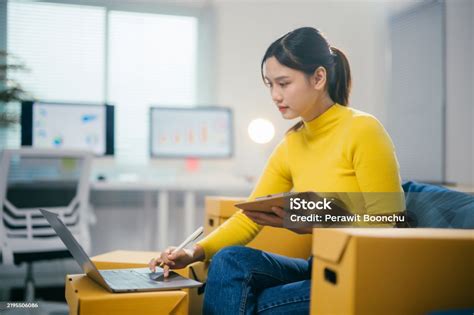 노트북에서 부지런히 일하면서 클립보드에 메모를 하고 새로운 사무실 환경에서 재고를 효과적으로 관리하고 재고 검사를 수행하는 젊은