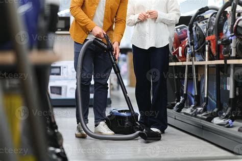 Young Beautiful Couple Buying New Vacuum Cleaner At Tech Store Having Fun Shopping Time