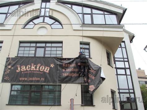 верхолаз продевает репшнур через металлические люверсы по периметру ...