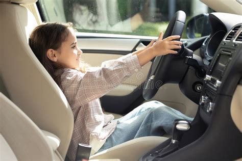 Cute Long Haired Girl Sitting At The Driver Seat And Looking Amused