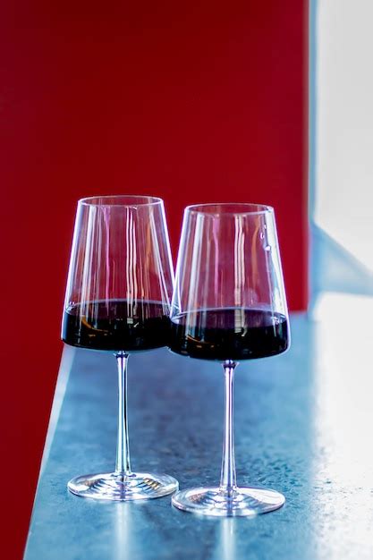 Premium Photo Two Glasses Of Wine On A Red Background