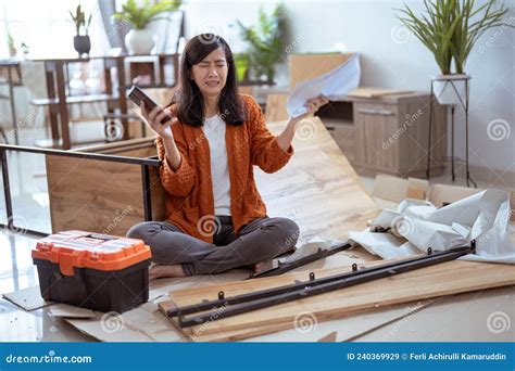 Frustrated Asian Woman While Assembling New Furniture Stock Image