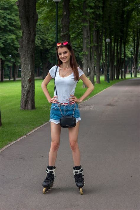 Skinny Charming Brunette Rides In The Park On Roller Skates Stock Photo Image Of Equipment