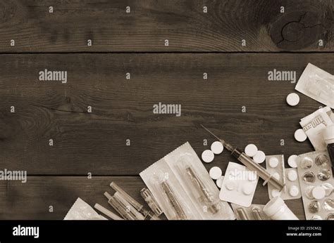 Narcotic Stuff With Many Pills And Syringes Lies On Wooden Table And