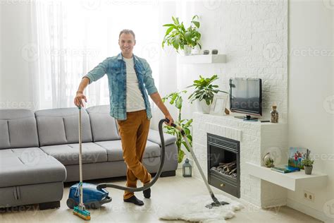 Caucasian Handsome Serious Young Man Vacuuming Cleaning Modern