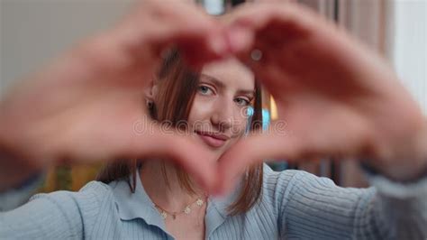 Young Pretty Woman Makes Symbol Of Love Showing Heart Sign To Camera