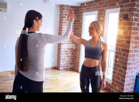 2 Young Beautiful Sportswomen Smiling Happy Standing Highing Five With