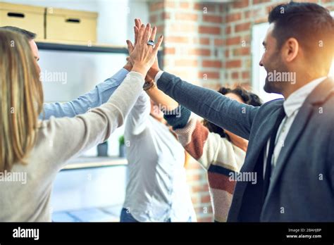 Group Of Business Workers Standing With Hands Together Highing Five At