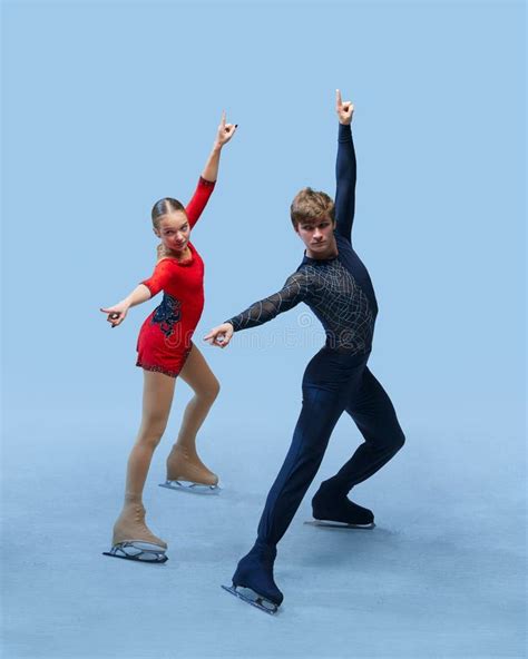 Figure Skating Pair Displaying Synchronized Pose With Poise And Elegance Against Cold Blue