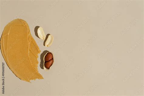 Close Up Smear Texture Of Creamy Peanut Paste With Whole Peanut And Shell On Beige Isolated