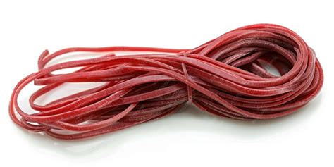 A Long Red String Of Candy Is Laying On A White Background Premium Ai Generated Image