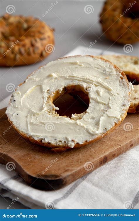 Homemade Whole Grain Bagel With Cream Cheese On A Rustic Wooden Board