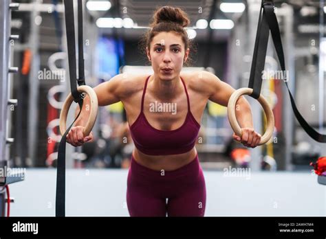 Athletic Woman Doing Some Pull Up Exercises In The Gymnastic Rings