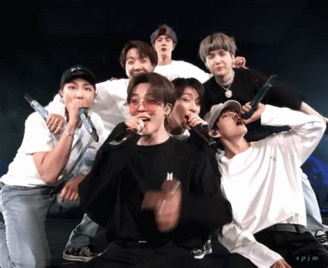 A Group Of Young Men Standing Next To Each Other In Front Of A