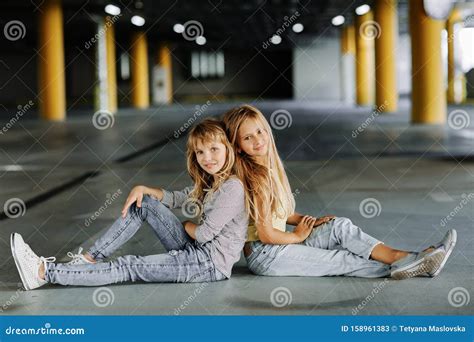 Two Beautiful Girls Having Fun And Playing In The Parking Lot Stock
