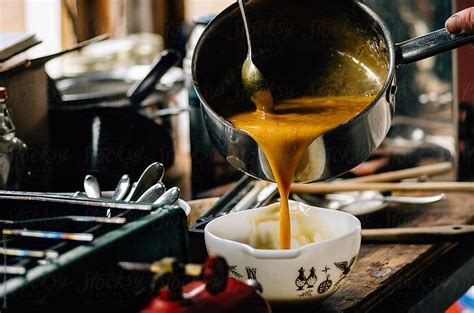 Pouring Boiling Syrup Into Bowl To Make Maple Candy By Stocksy