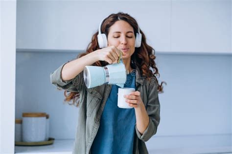 Woman Dances To Music In Headphones With Coffee In Cup Stock Image