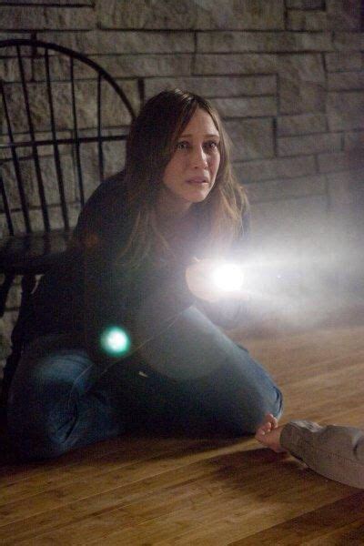 A Woman Sitting On The Floor Next To A Fire Hydrant With A Flashlight In Her Hand