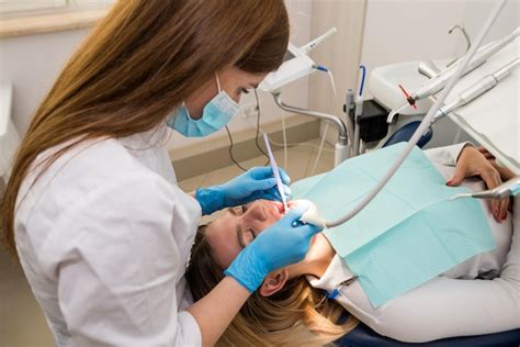 Premium Photo A Female Dentist Treats A Patients Teeth The Dentist