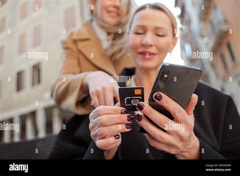Blonde Woman Changing A Sim Card In Her Ohone Her Freind Helping Stock Photo Alamy