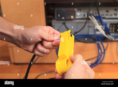 Cable Installer Using A Tool To Remove The Outer Insulation Sheath From