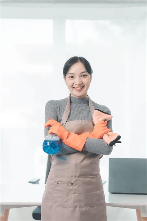 Cute Asian Girl Cleaning The Living Room In The Apartment Housekeeper