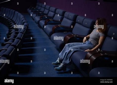 Caucasian Red Haired Woman Sits On The Last Row In A Cinema In An Empty