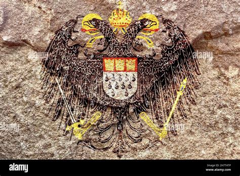 Faded Coat Of Arms Of Cologne Isolated On Weathered Solid Rock Wall