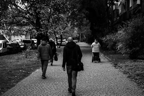 A Black And White Photo Of People Walking Down A Sidewalk Photo Free