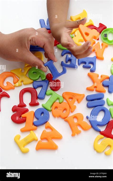 Brown Hands Of Mom And Daughter Play With The Game Of Colored Letters
