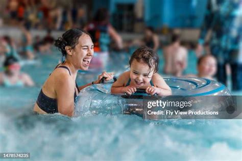 Mom And Daughter Having Fun Swimming In A Wave Pool High Res Stock