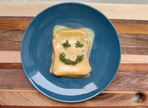 Parsley In The Shape Of A Smiley Face On Grilled Cheese On A Blue Plate