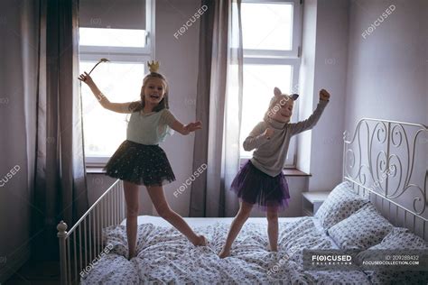 Girls In Costume Dancing On Bed In Bedroom — Leisure Siblings Stock