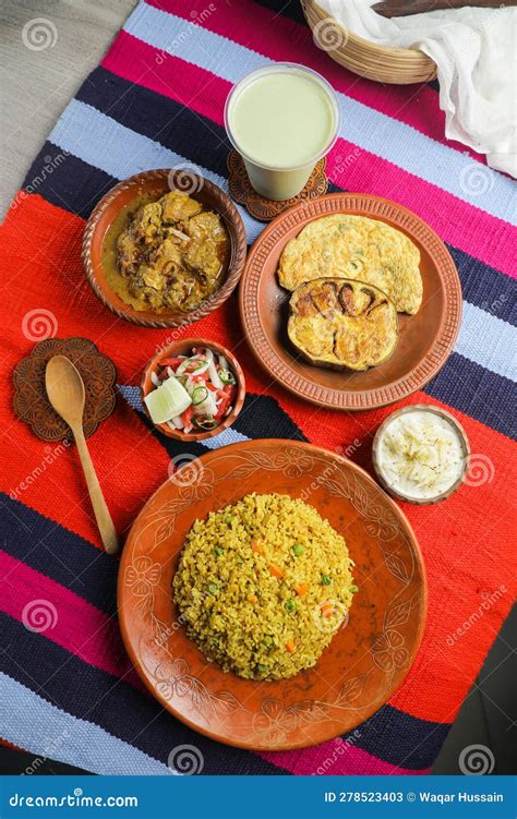 Achari Chicken Khichuri Combo With Egg Plant And Omelet Borhani Salad And Chui Pitha Served In