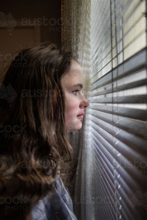 Image Of Teenage Girl At Window Looking Out Venetian Blinds Austockphoto