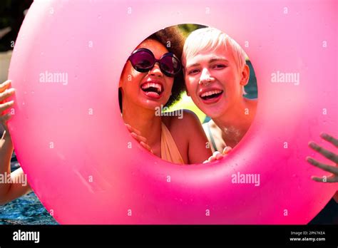 Portrait Of Happy Diverse Female Friends Having Pool Party Holding