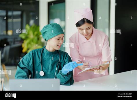Asian Doctors And Nurses Using Computers And Documents To View Patient