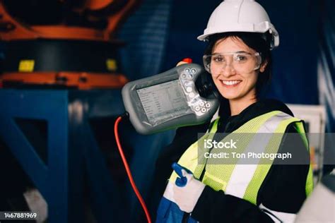 Female Technician Engineer Using Controller Checking Robotic Machine