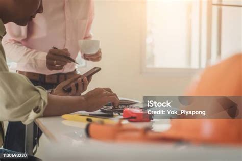 사무실의 회의 건물 계획 설계 프로젝트 중에 전화를 통해 건축가 또는 엔지니어가 메시지를 읽습니다 건설 엔지니어링 도구 및 구조 개념 개념에 대한 스톡 사진 및 기타 이미지