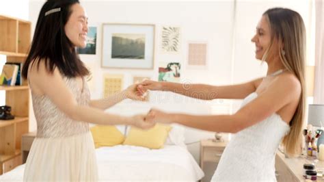 Friends Bride And Bridesmaid Dance In Bedroom For Cheerful Bachelorette Fun Before Wedding