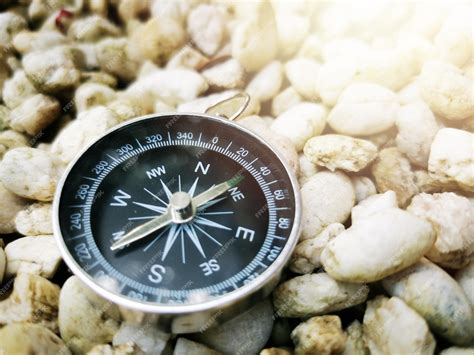 Premium Photo Compass Placed On A Small Rock Sunset Background Text