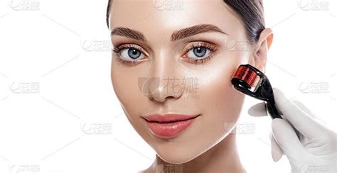 美丽的女人在微针过程中。美容师用微针真皮滚轮做女性皮肤治疗，特写。孤立在白色素材 花瓣网